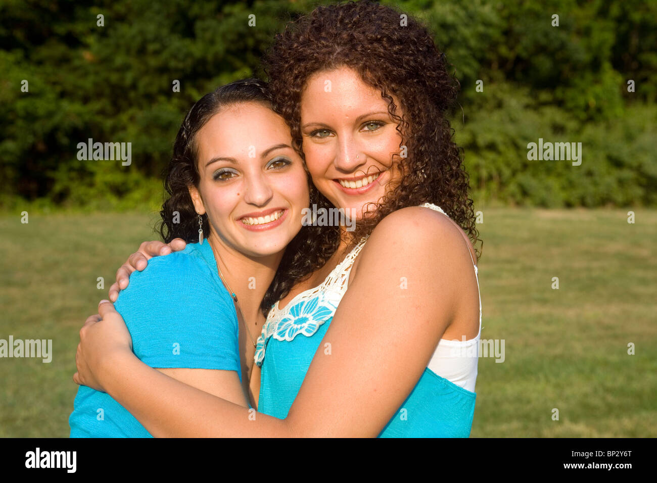 Best friends hug on a clear afternoon in a Connecticut, USA, meadow ...