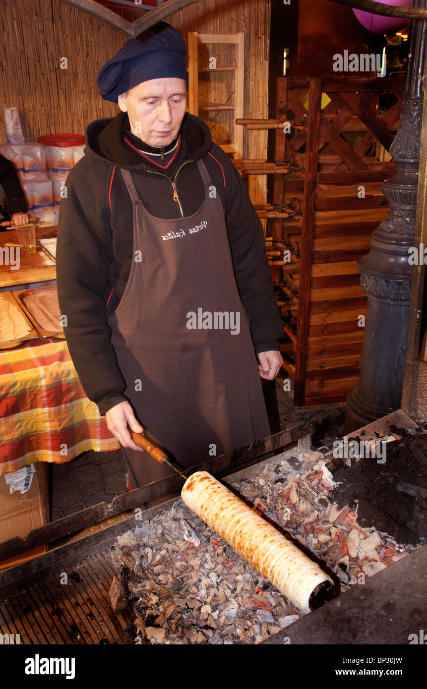 COOKING KURTOS KALACS ON WOODEN SPIT OVER HOT COALS Stock Photo - Alamy