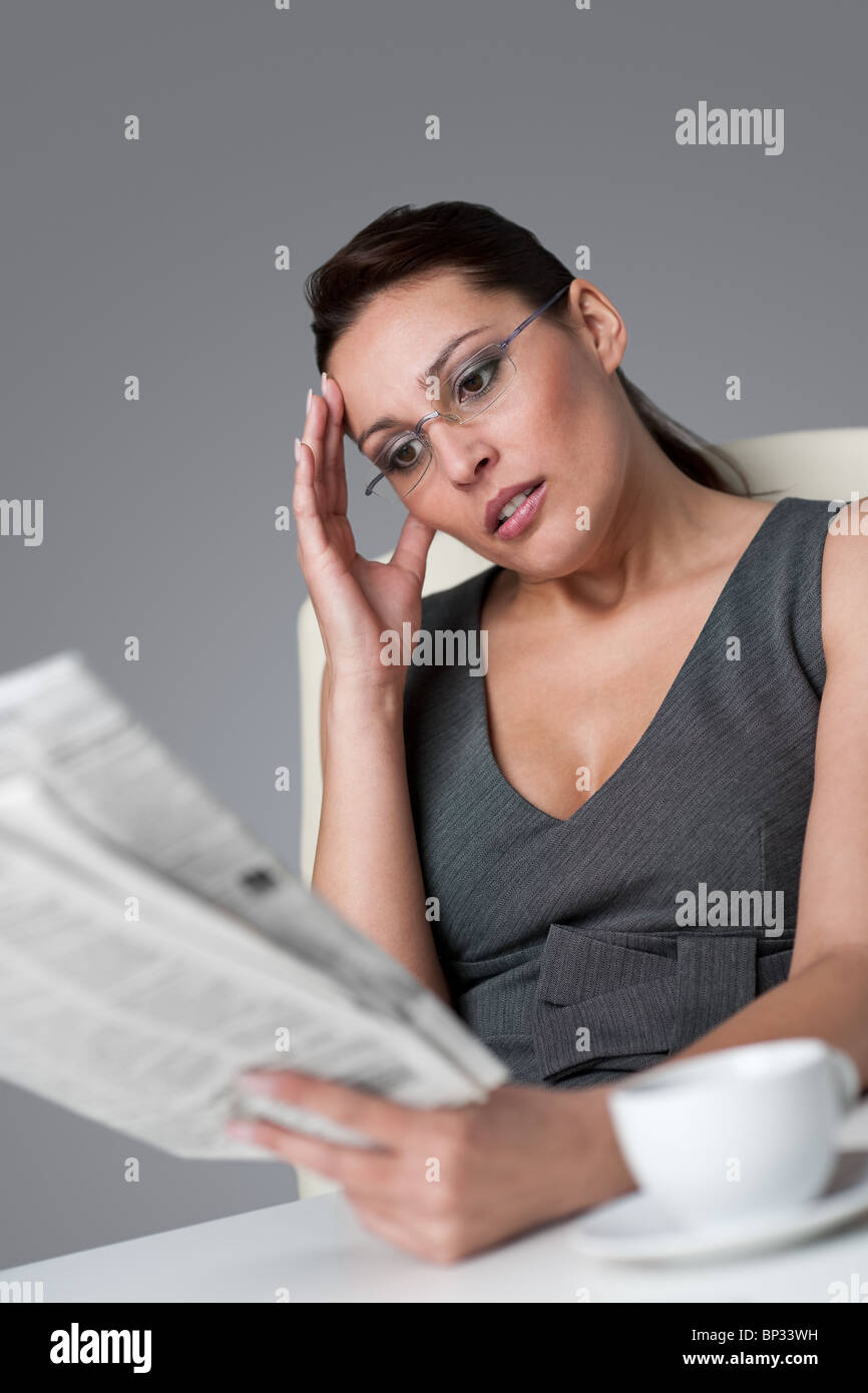 Thoughtful successful businesswoman read newspaper at office with ...