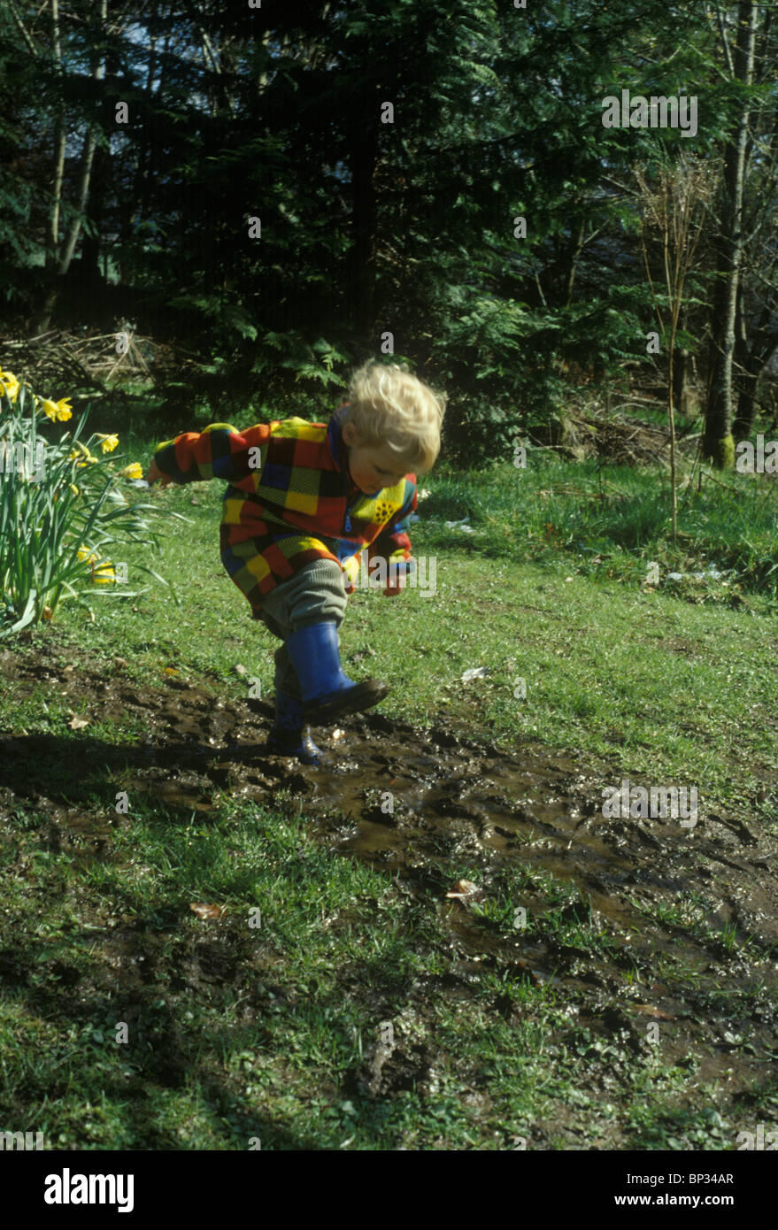little boy stamping in mud Stock Photo - Alamy
