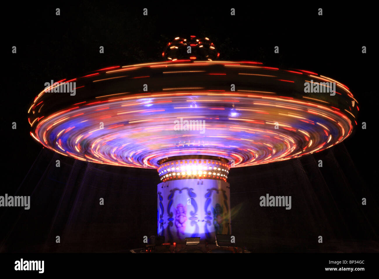 Blue and red spinning carousel at night in the UK Stock Photo - Alamy