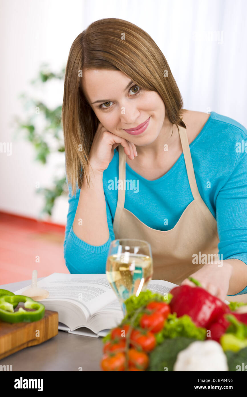 Cooking - Smiling woman with glass of white wine in kitchen with pasta ...