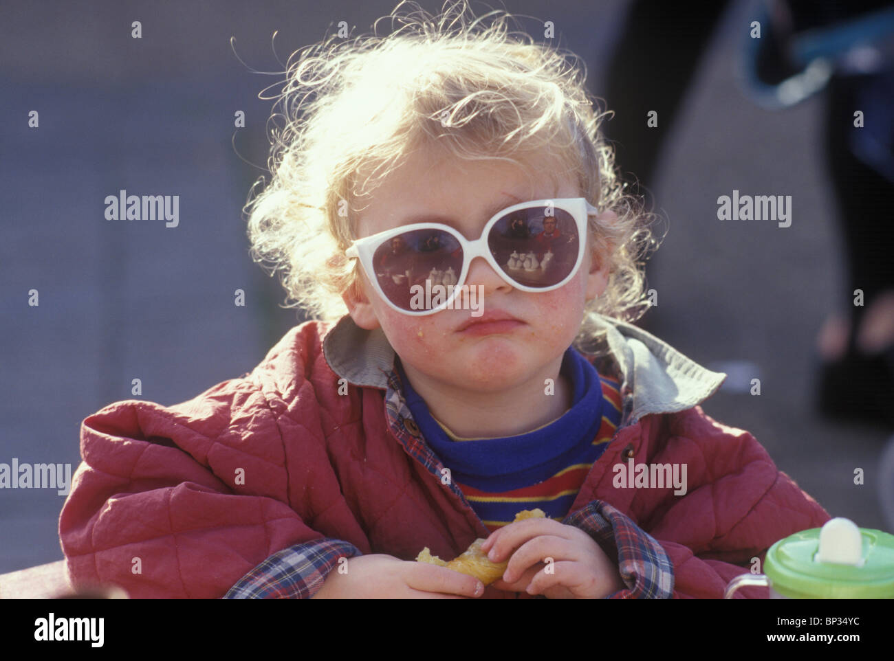 little boy wearing large shades looking grumpy Stock Photo - Alamy
