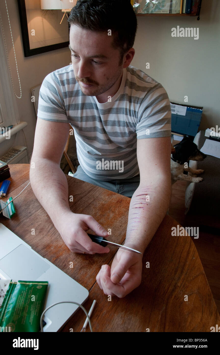 Extremely depressed young man self harming and suicidal Stock Photo - Alamy