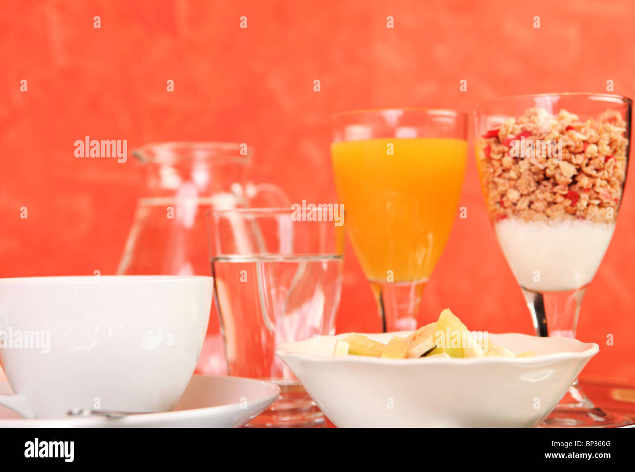 A healthy breakfast consisting of a fruit salad, glass of juice, coffee ...