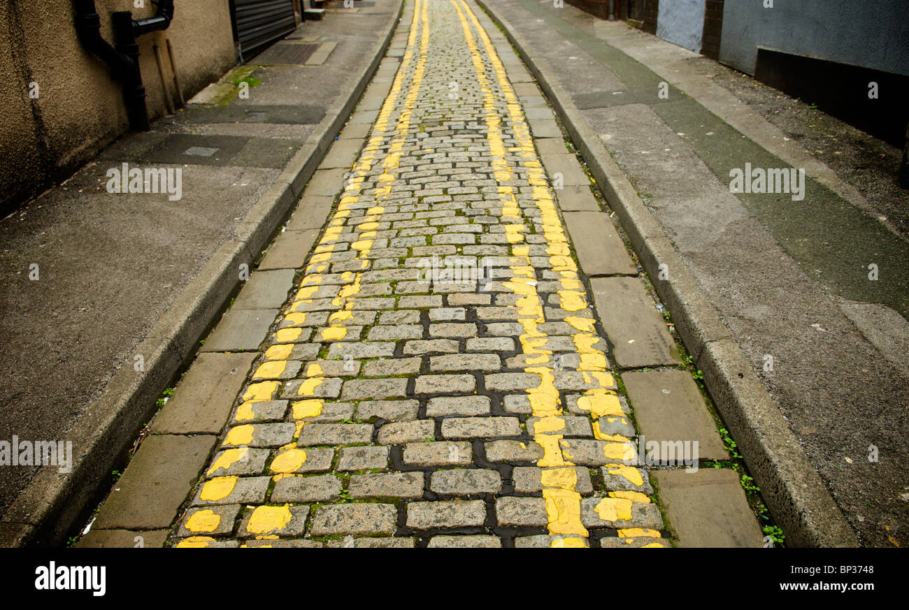 Very narrow cobbled back street painted with double yellow lines Stock ...