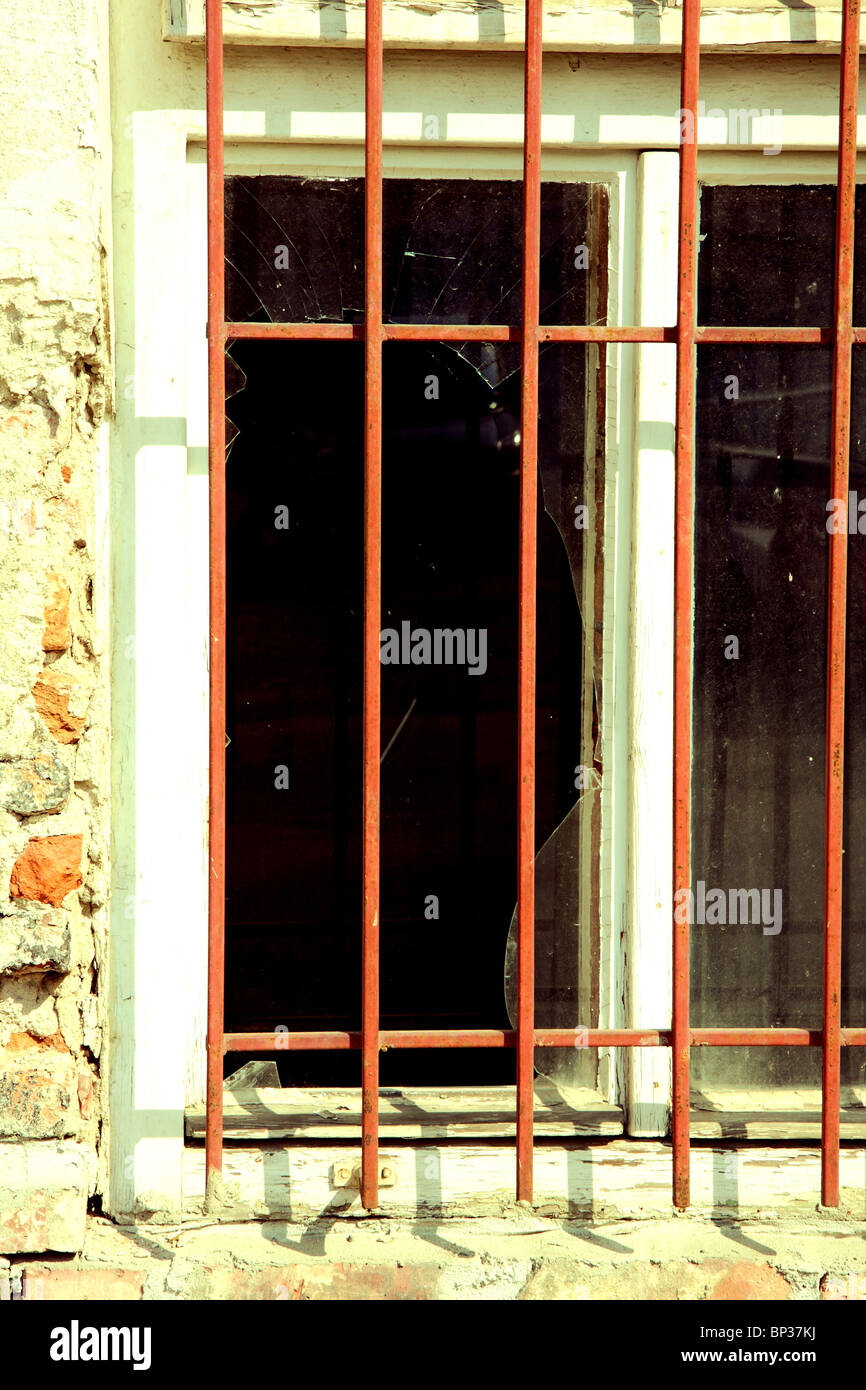 Barred broken window Stock Photo - Alamy