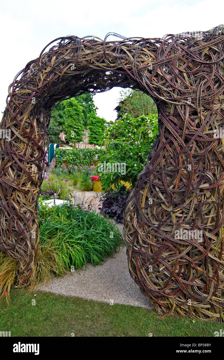 A crafted wicker archway into a garden Stock Photo - Alamy