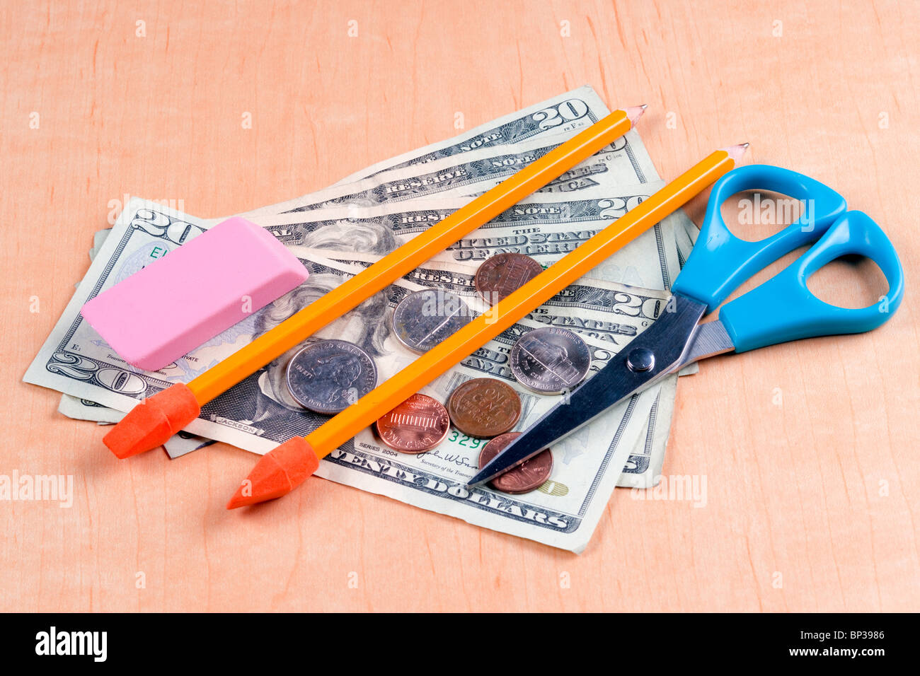 Pencils eraser and scissors with paper and coin money Stock Photo - Alamy