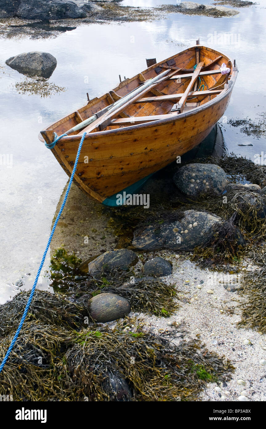 Traditional wooden rowing boat beached on a rocky Island in Norway ...