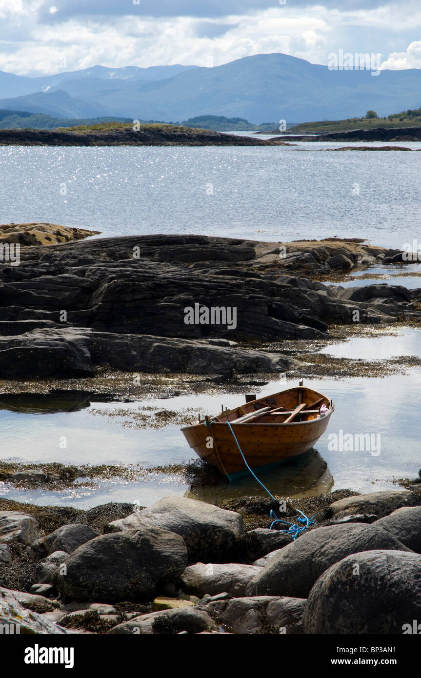 Traditional wooden rowing boat beached on a rocky Island in Norway ...