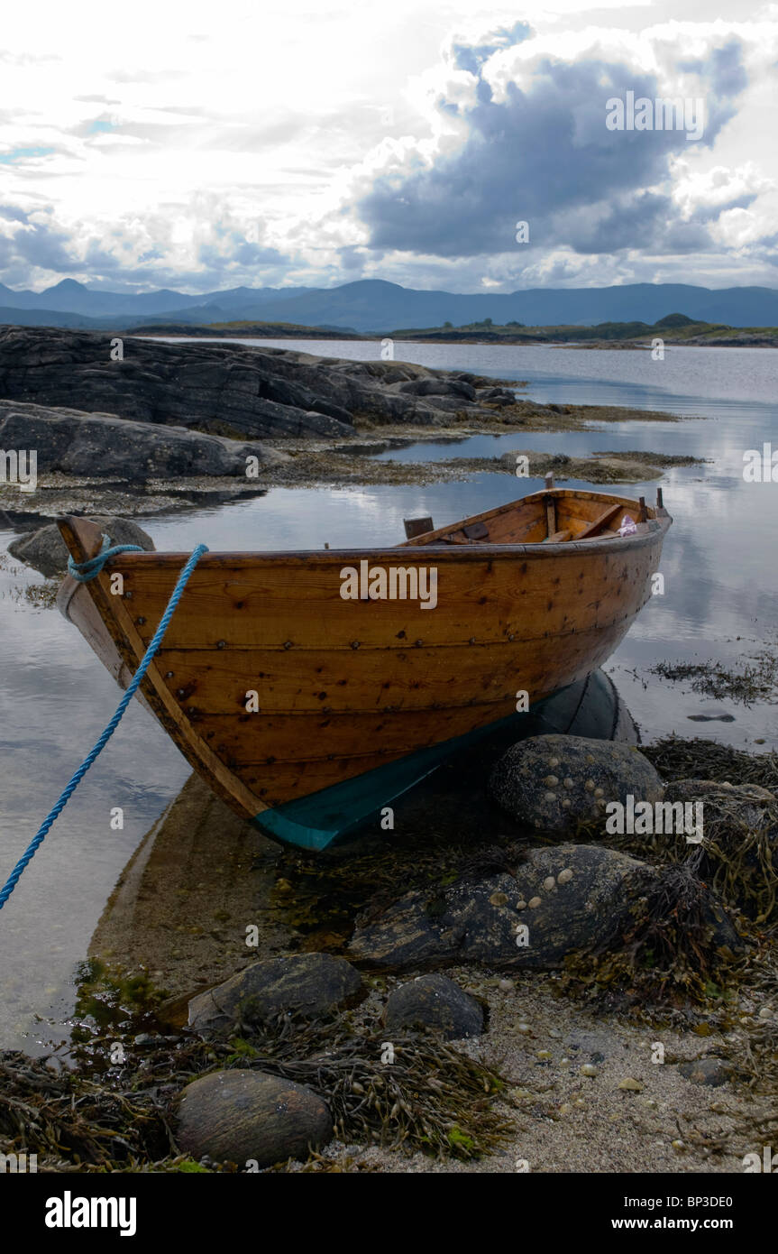 Traditional wooden rowing boat beached on a rocky Island in Norway ...