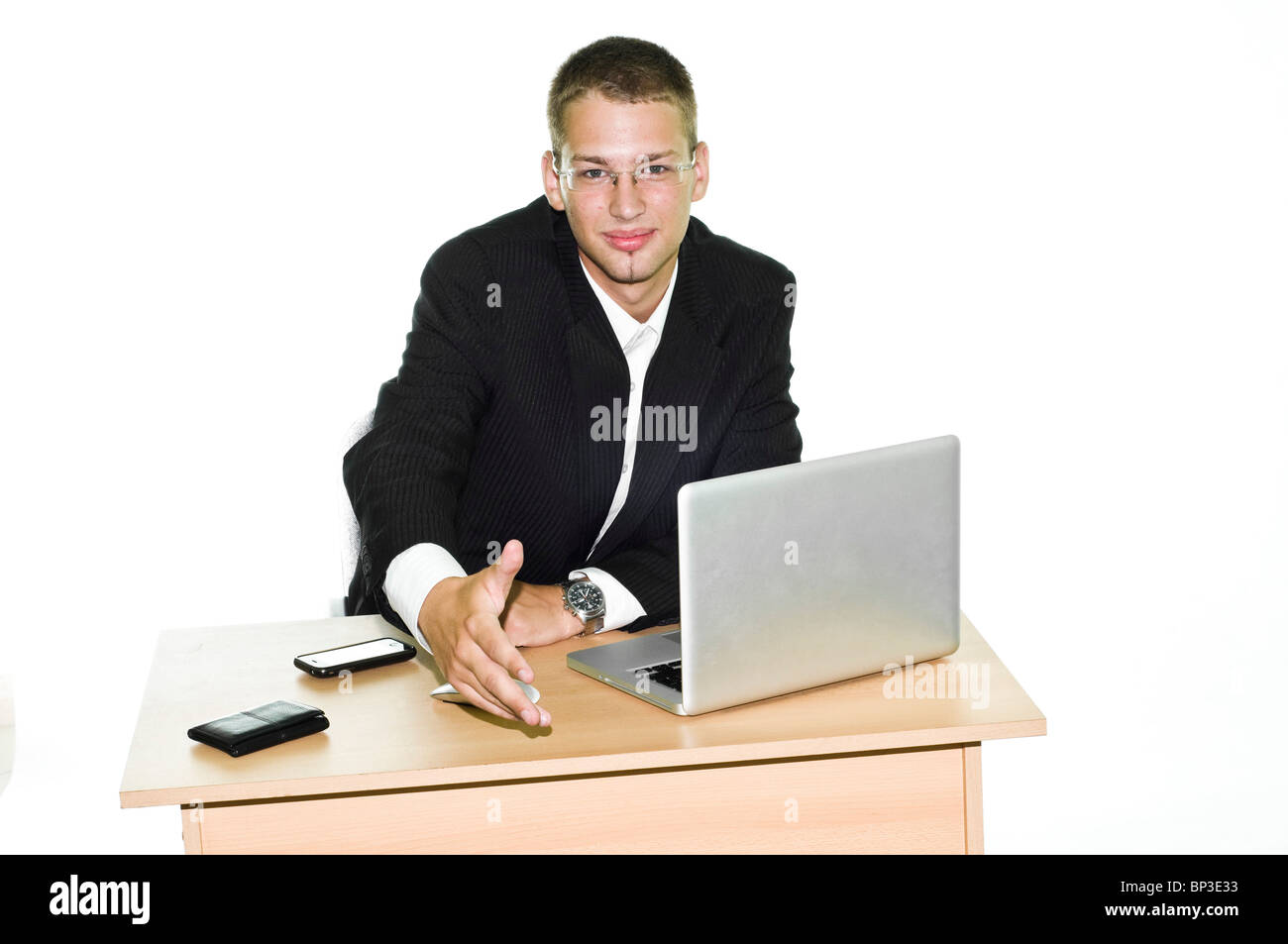 Young businessman holding hand over his desk with laptop, mouse and ...