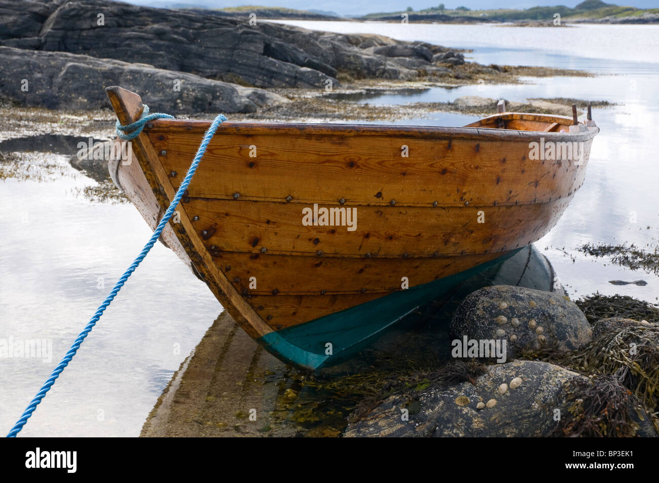 Traditional wooden rowing boat beached on a rocky Island in Norway ...