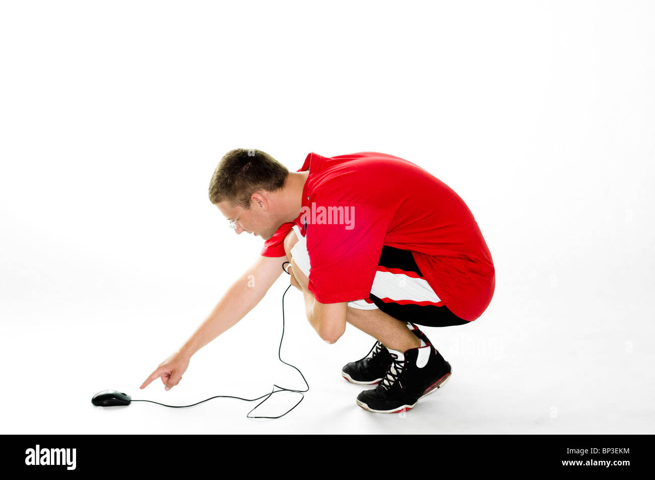 Young man with mouse (computer) stroking it as it was animal, funny ...