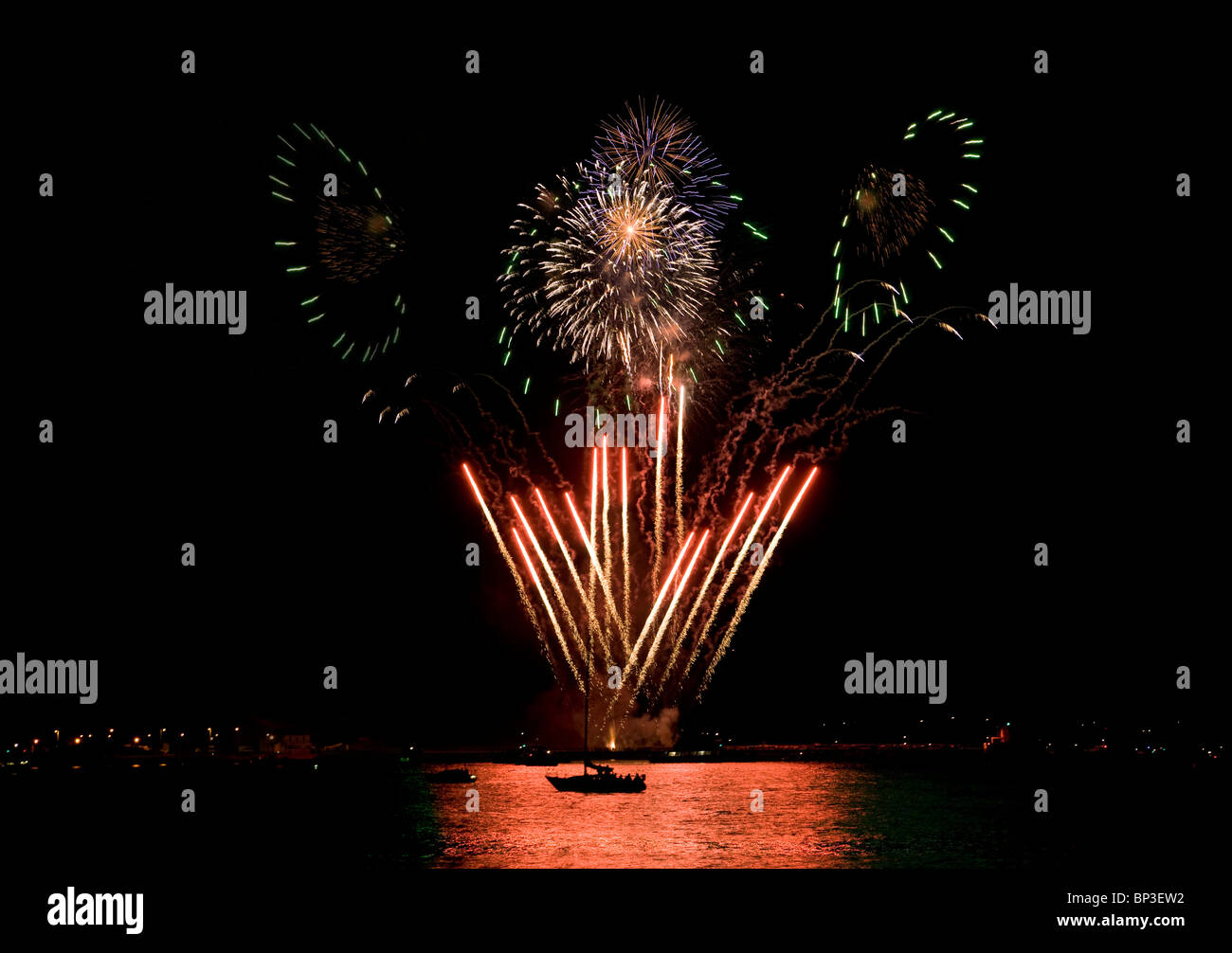 multi coloured fireworks erupting in the night sky over water Stock ...