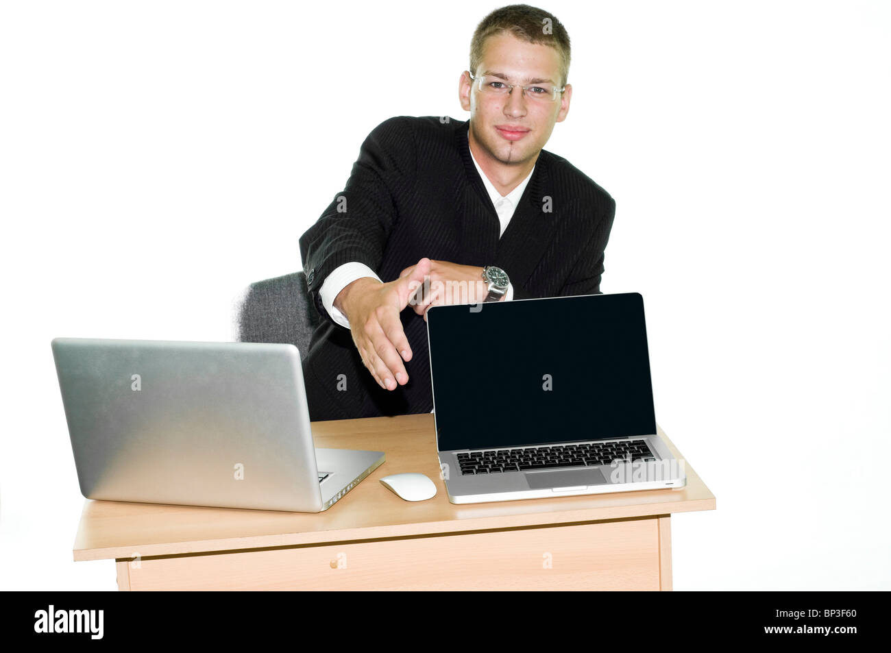 Young businessman holding hand over desk with laptops, smiling Stock ...