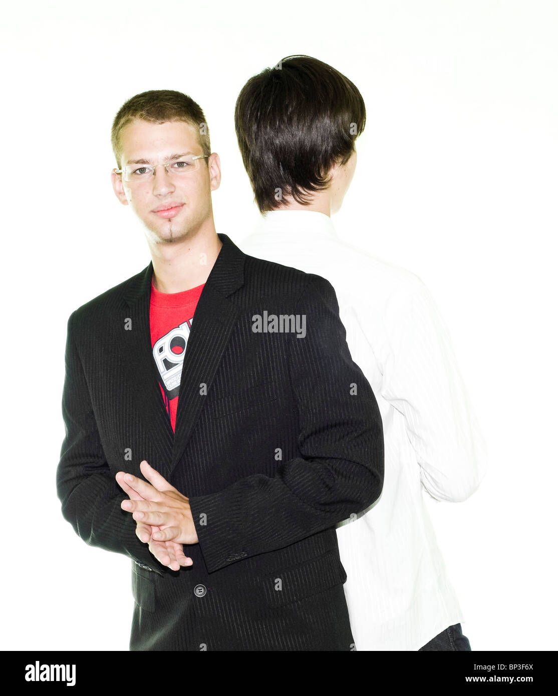Two young businessmen leaning on each other, isolated on white ...