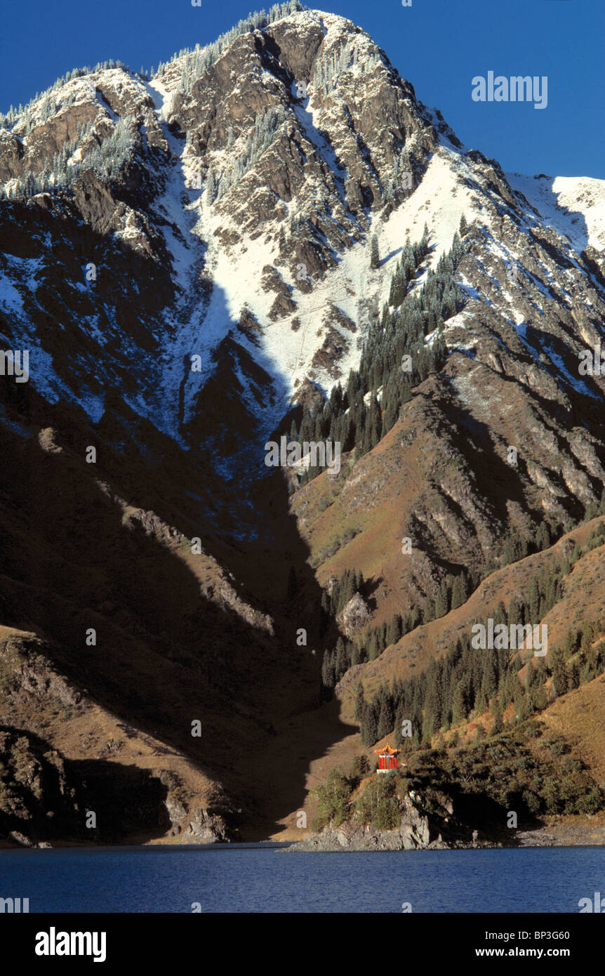 China, Xinjiang, Heavenly Lake. Snow-dappled Bogda Peak towers over ...