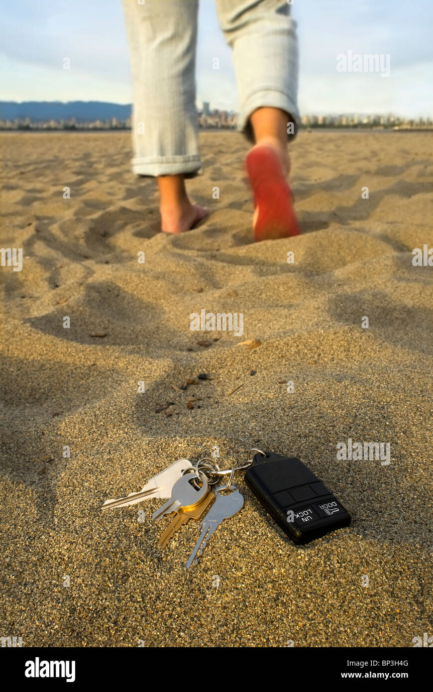 A person walks away, leaving their keys in the sand at the beach Stock ...