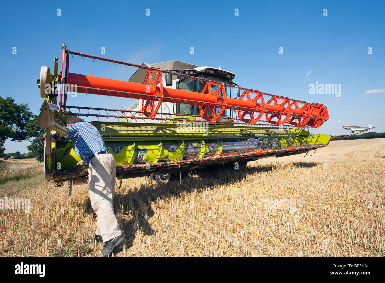Farmer cleaning blades on a combine harvestor Stock Photo - Alamy