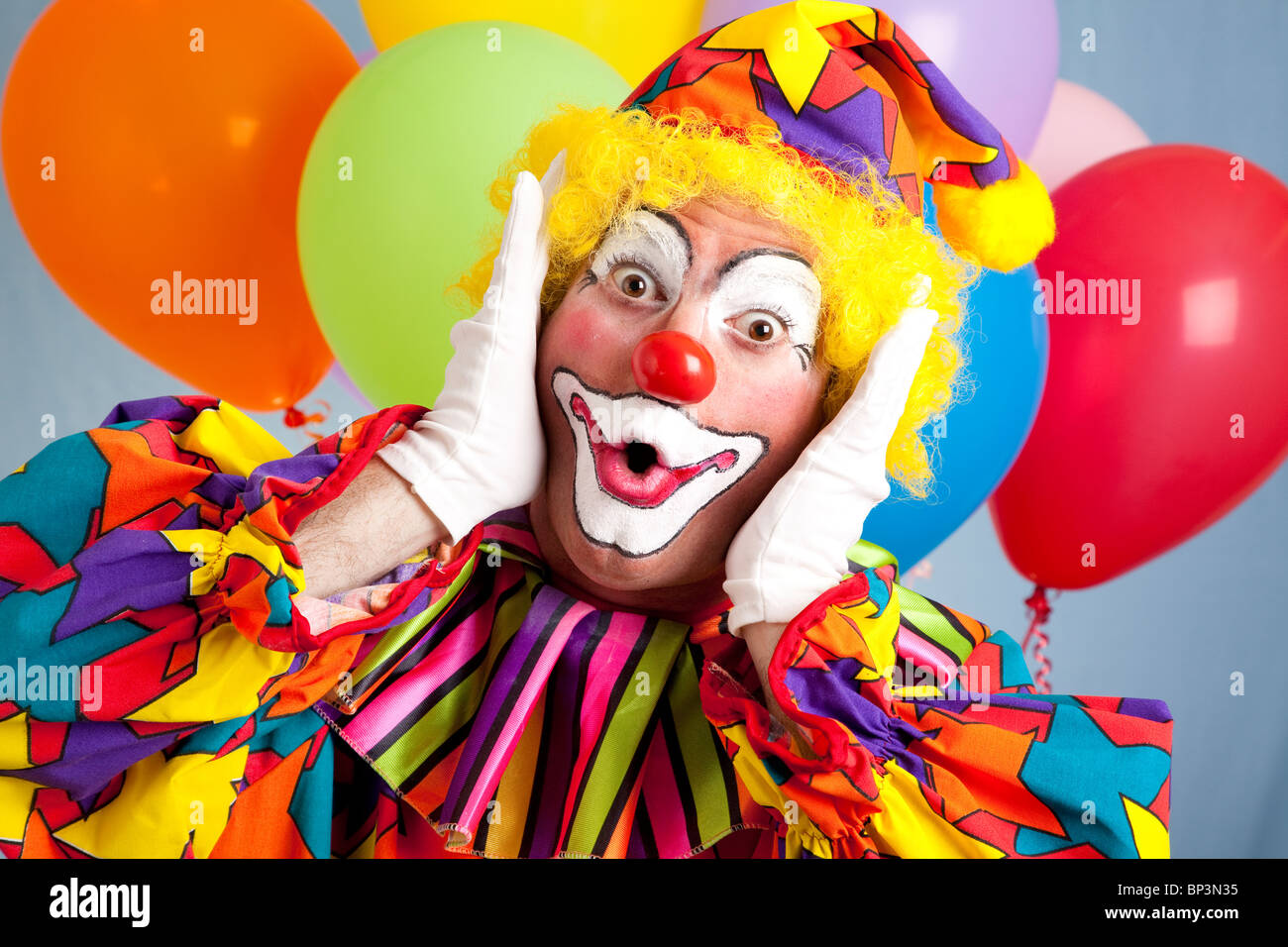 Birthday clown in full costume, looking surprised Stock Photo - Alamy