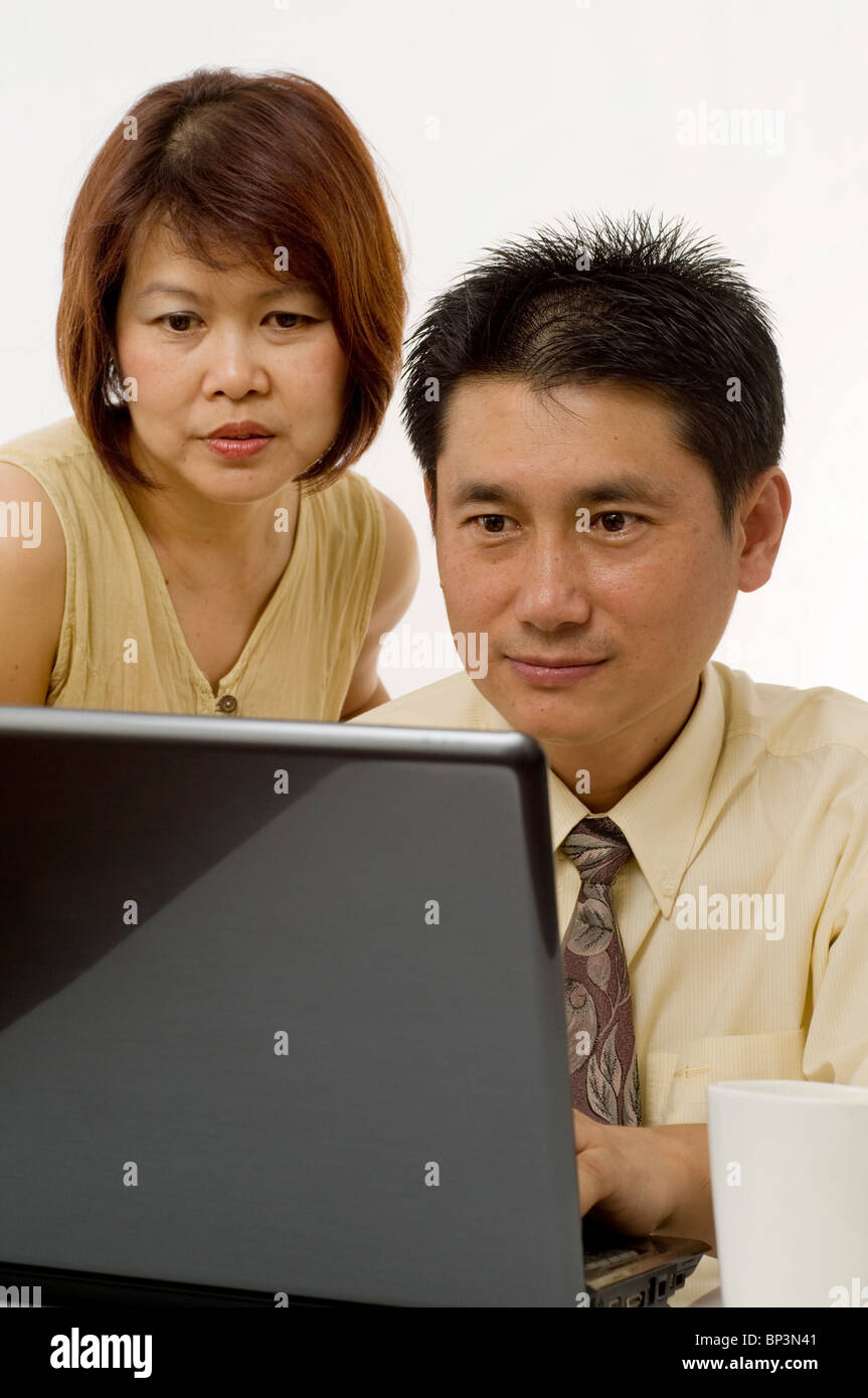 Asian man and woman using computer together Stock Photo - Alamy