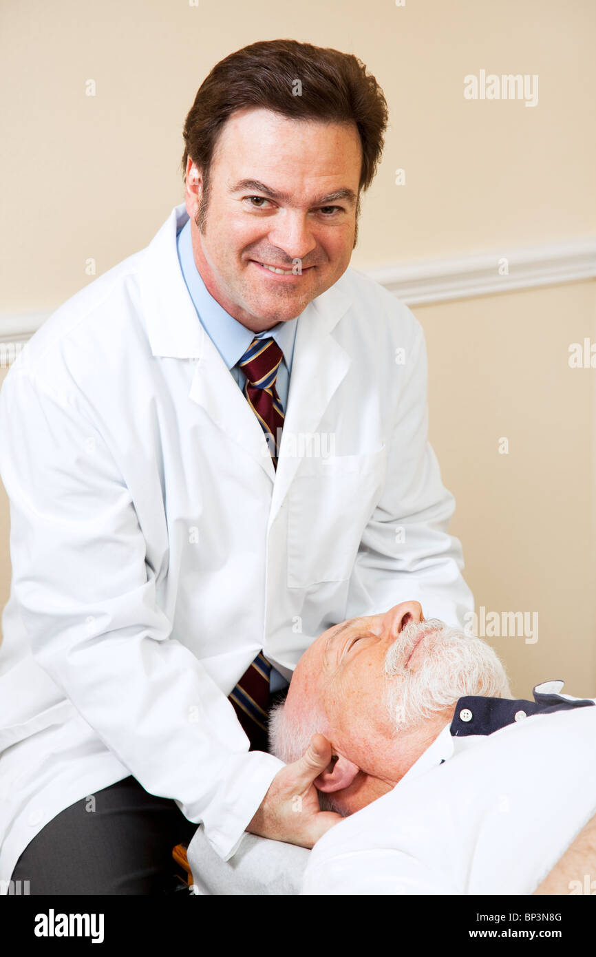 Handsome, smiling chiropractor adjusting a senior man's neck Stock ...