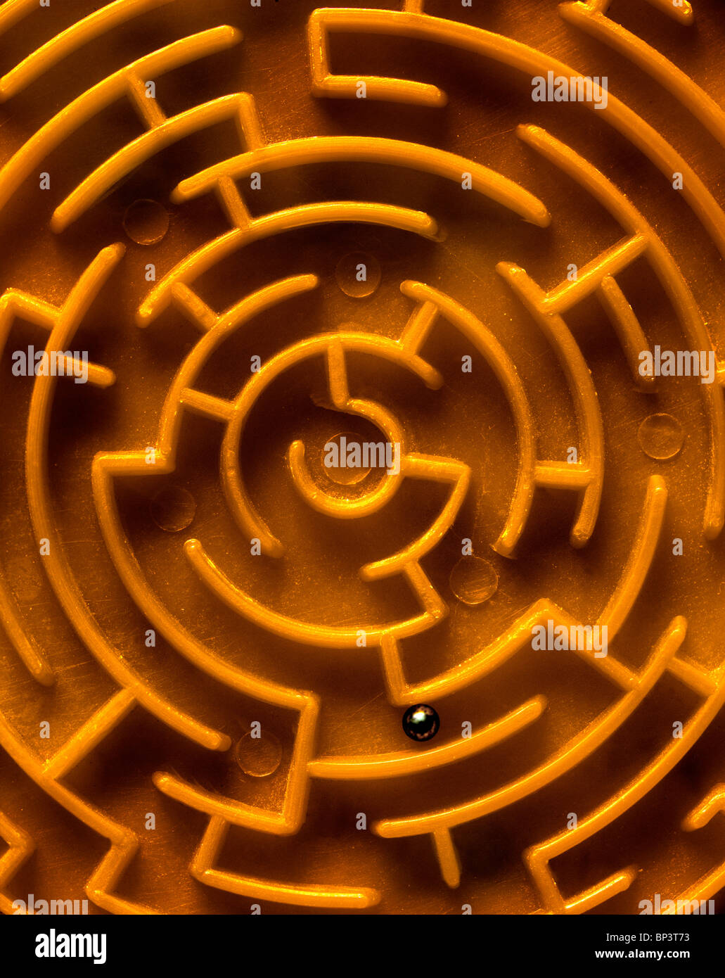 Close up of the centre of a circular maze with a silver ball. (The ...