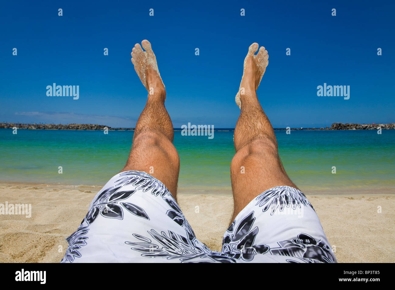 Men's legs on a sandy beach Stock Photo - Alamy