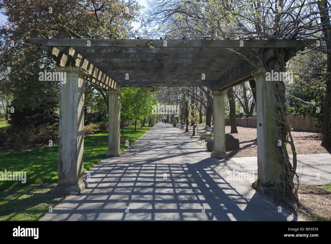 an architectural structure in a garden with walkway running underneath ...