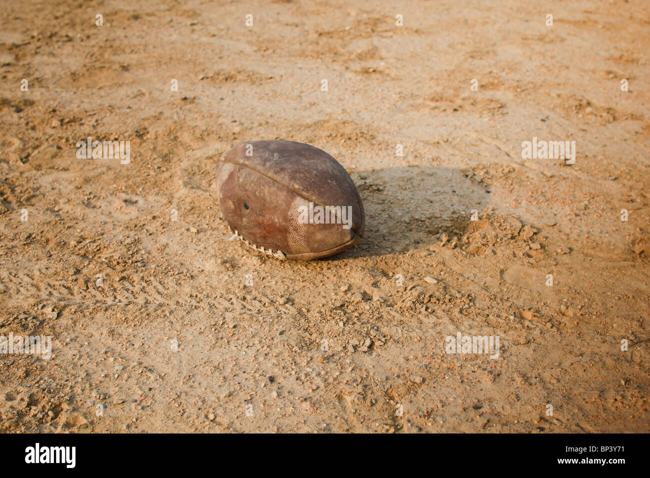 An old dusty beat up football on a dirt lot Stock Photo - Alamy