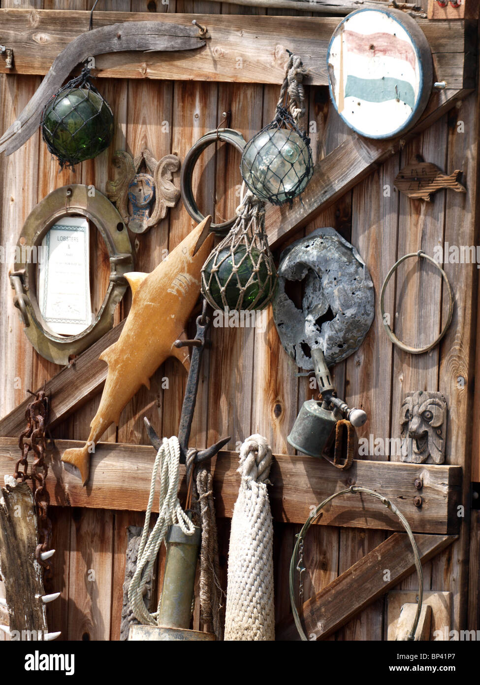 Unusual collection of objects on a boat shed door, Bude, Cornwall, UK ...