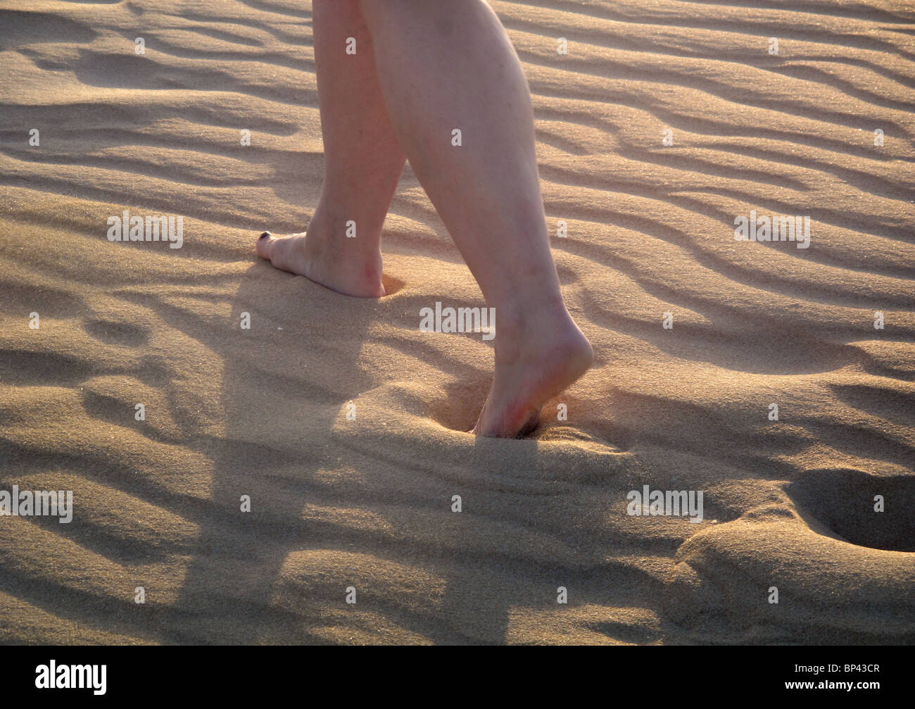Bare feet walking on wind rippled sand in low sun Stock Photo - Alamy
