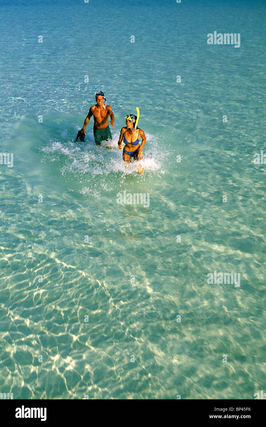 Asia, Maldives. Couple running through waves with diving gear Stock ...