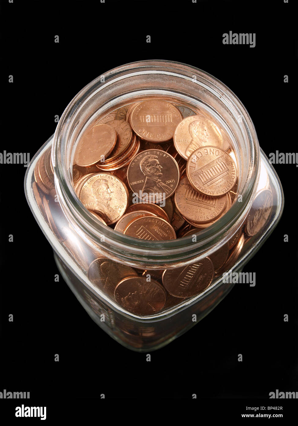New clean pennies in a jar isolated on black Stock Photo - Alamy