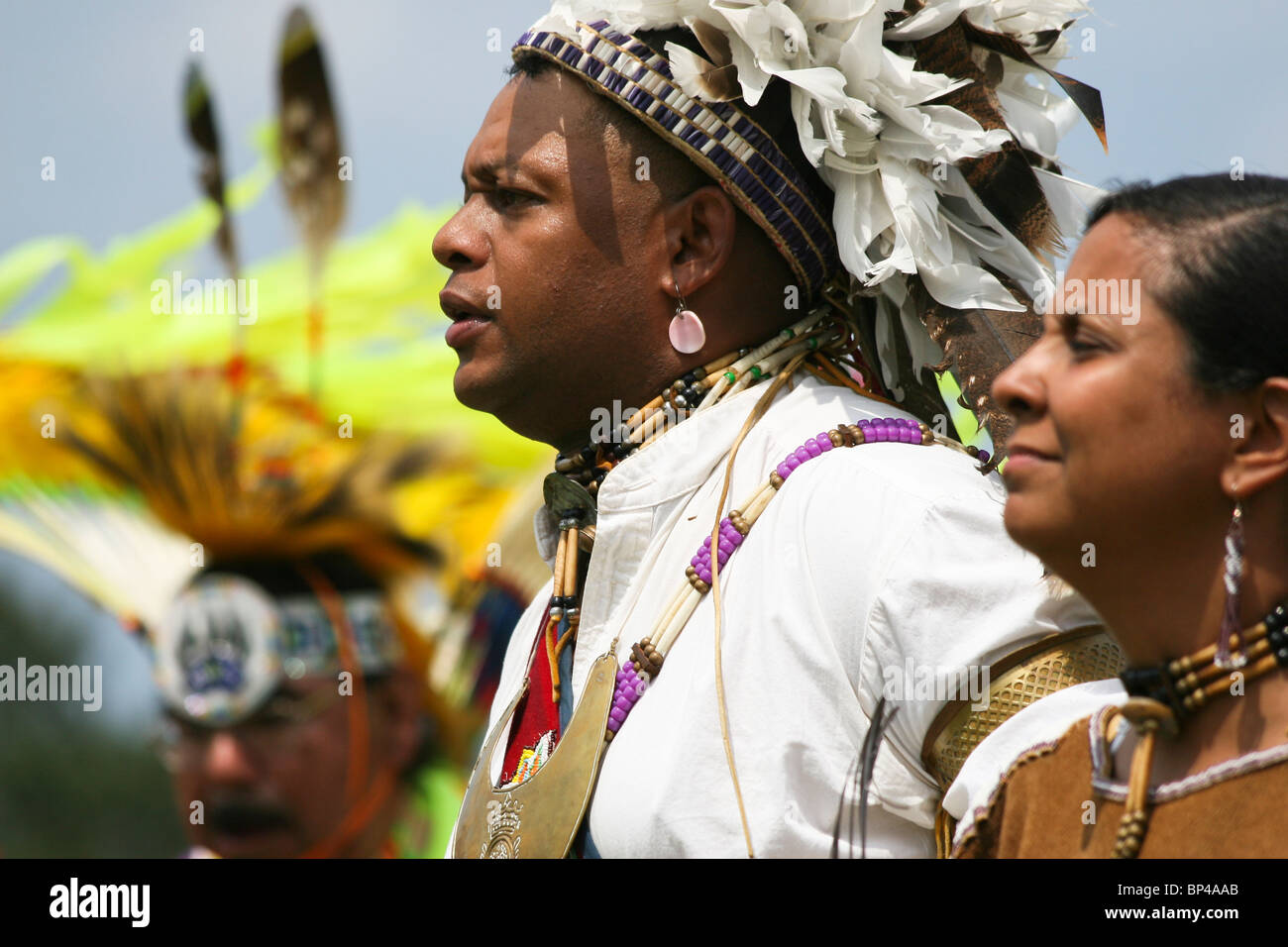 Native Americans in full traditional regalia parade in the dance circle ...
