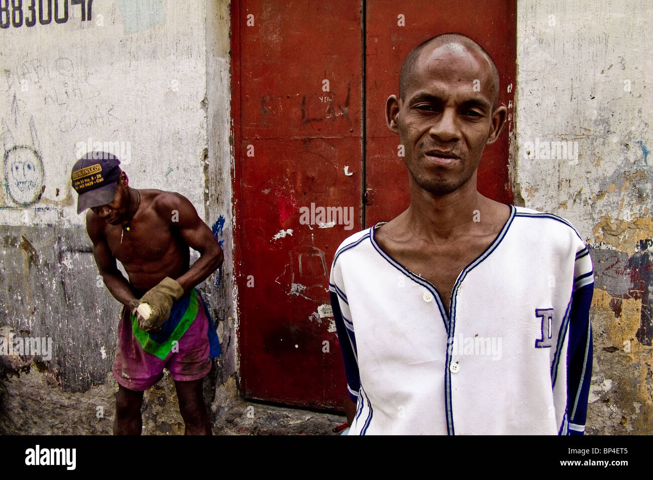 A Colombian slum dweller standing in front of a rented house in the ...