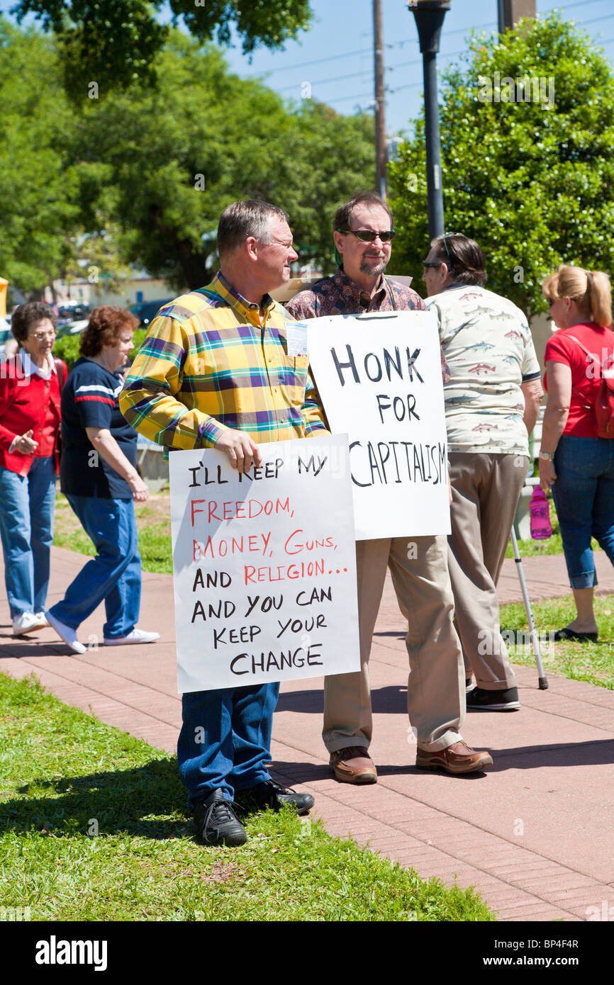 Middle aged men carry signs protesting socialism and President Obama's ...