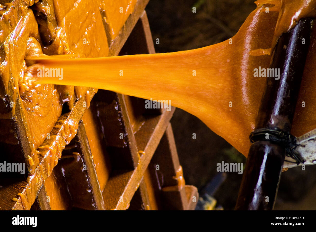 Hot and liquid panela being poured into a wooden form during the ...