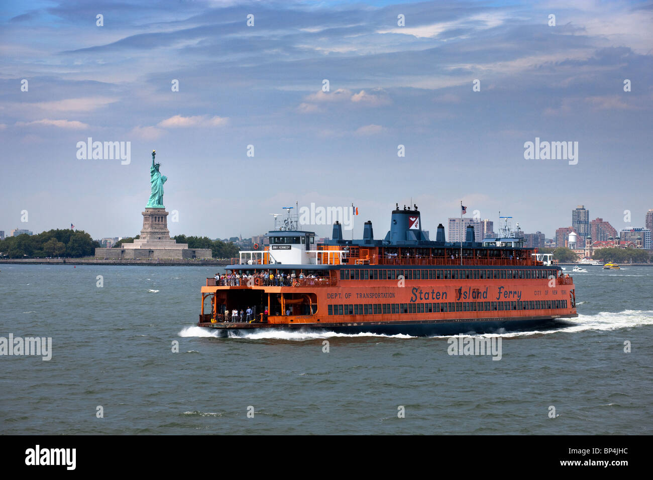 The Staten Island Ferry passes in front of the Statue of Liberty Stock ...