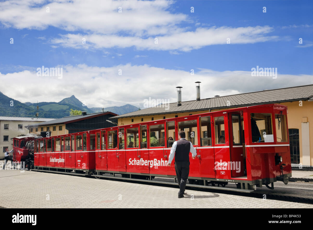 Red steam train on rack and pinion in railway station platform to ...