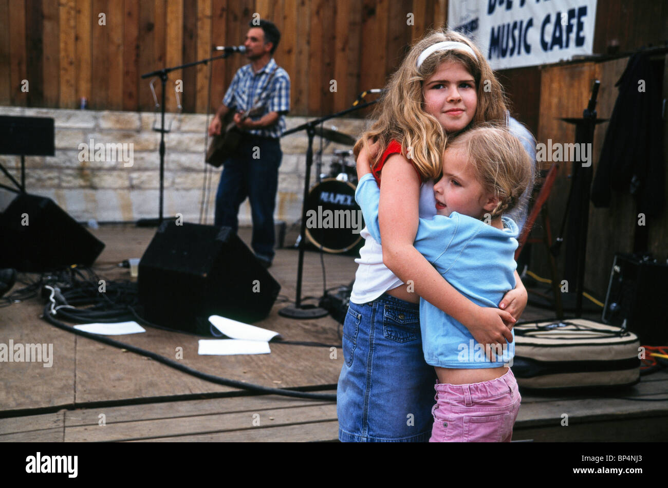Two young girls hugging each other during a concert. South by Southwest ...