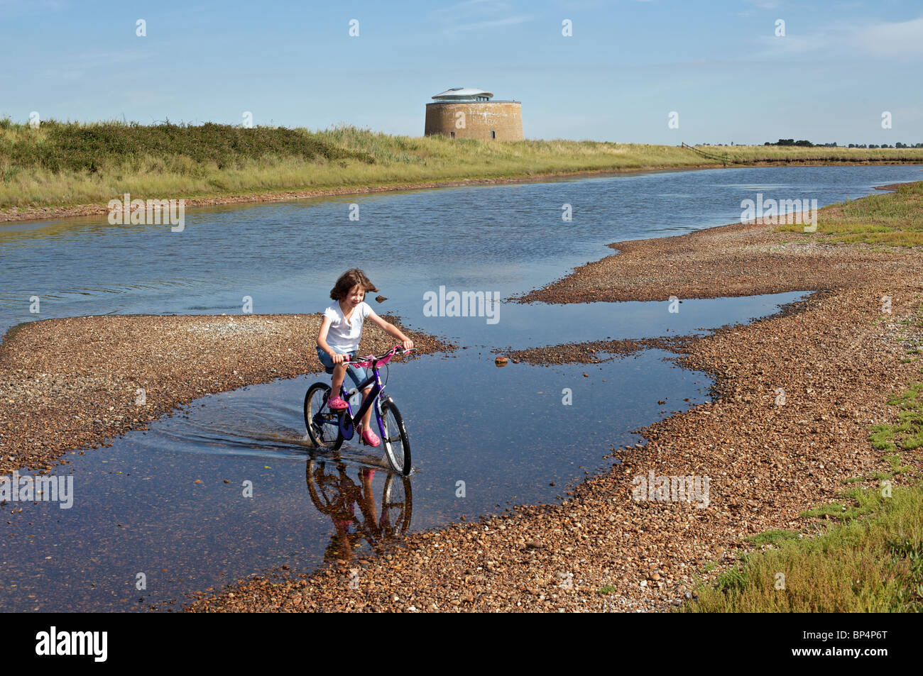 Girl riding cycle on the Suffolk coast path, Bawdsey, England Stock ...