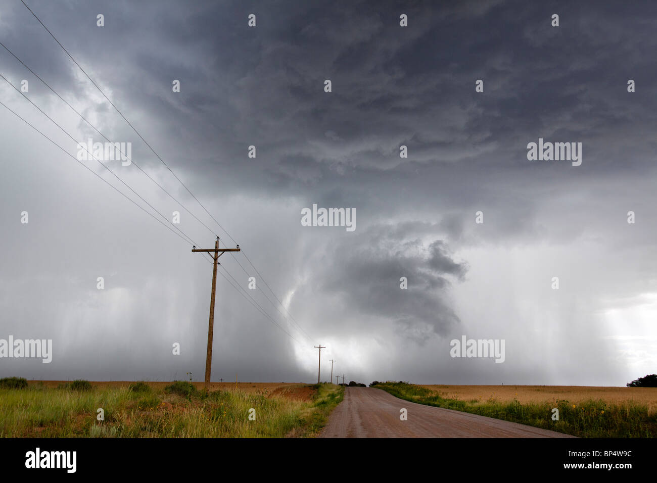 Angry looming cumulus thunder storm clouds releasing rain in a rural ...
