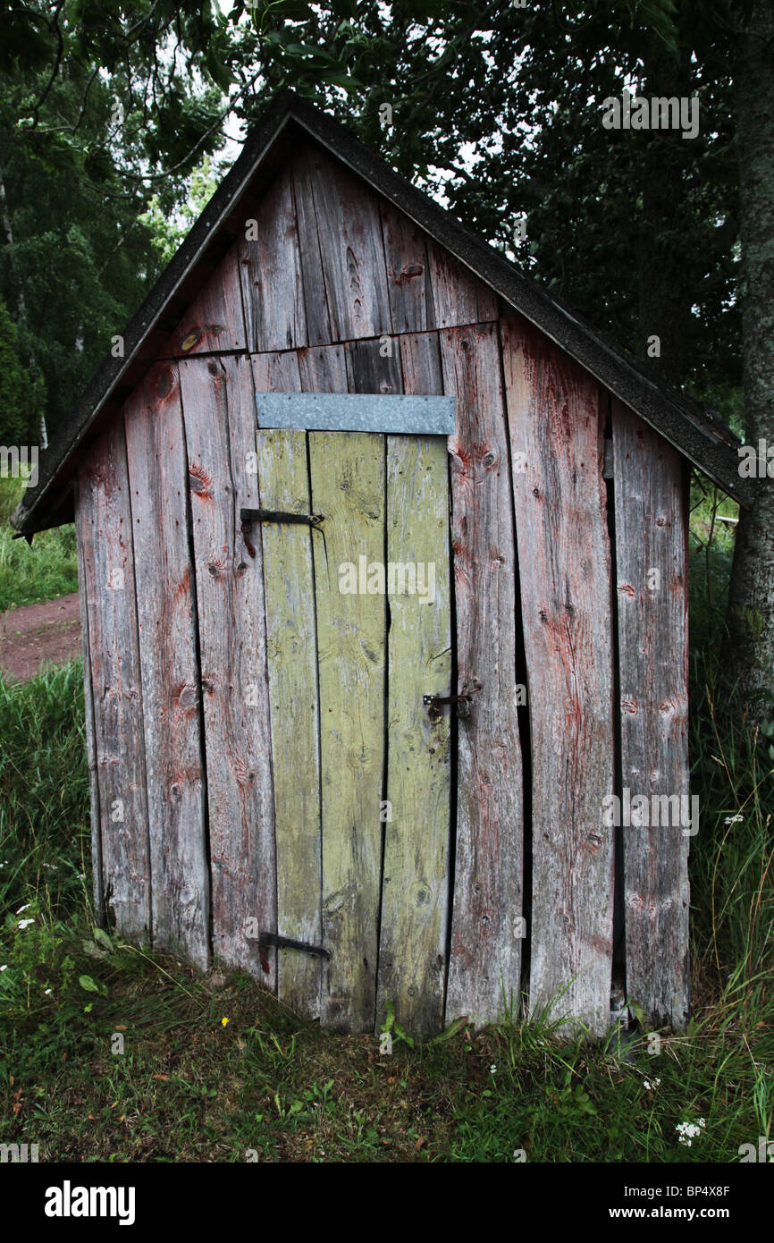 Traditional Nordic shed outhouse with odd shaped door detail flaking ...