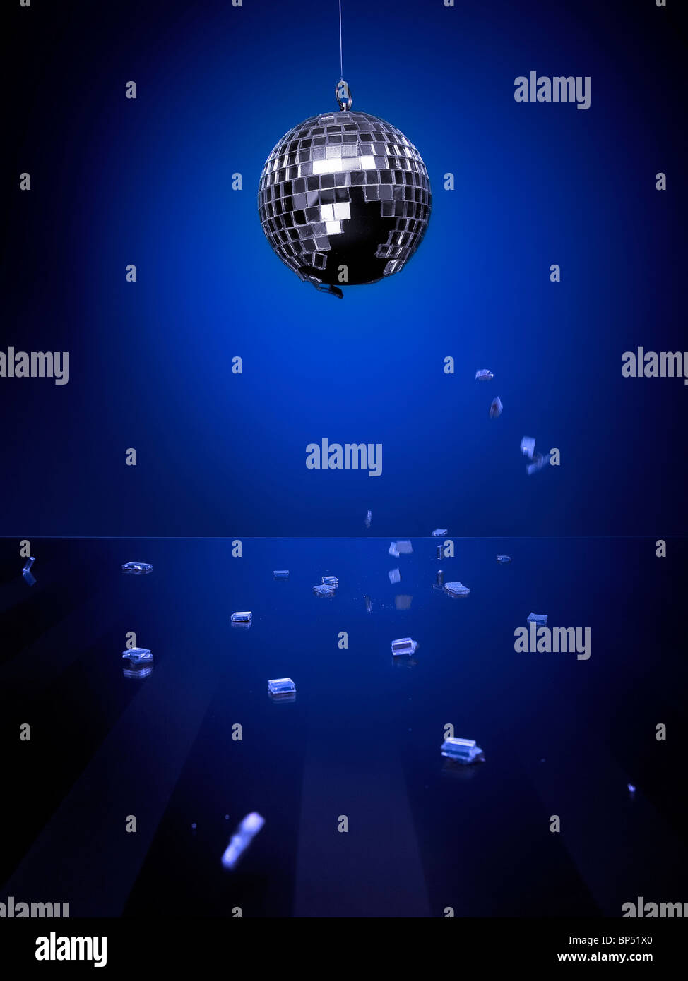 Broken disco-ball isolated on blue background with pieces of mirror ...
