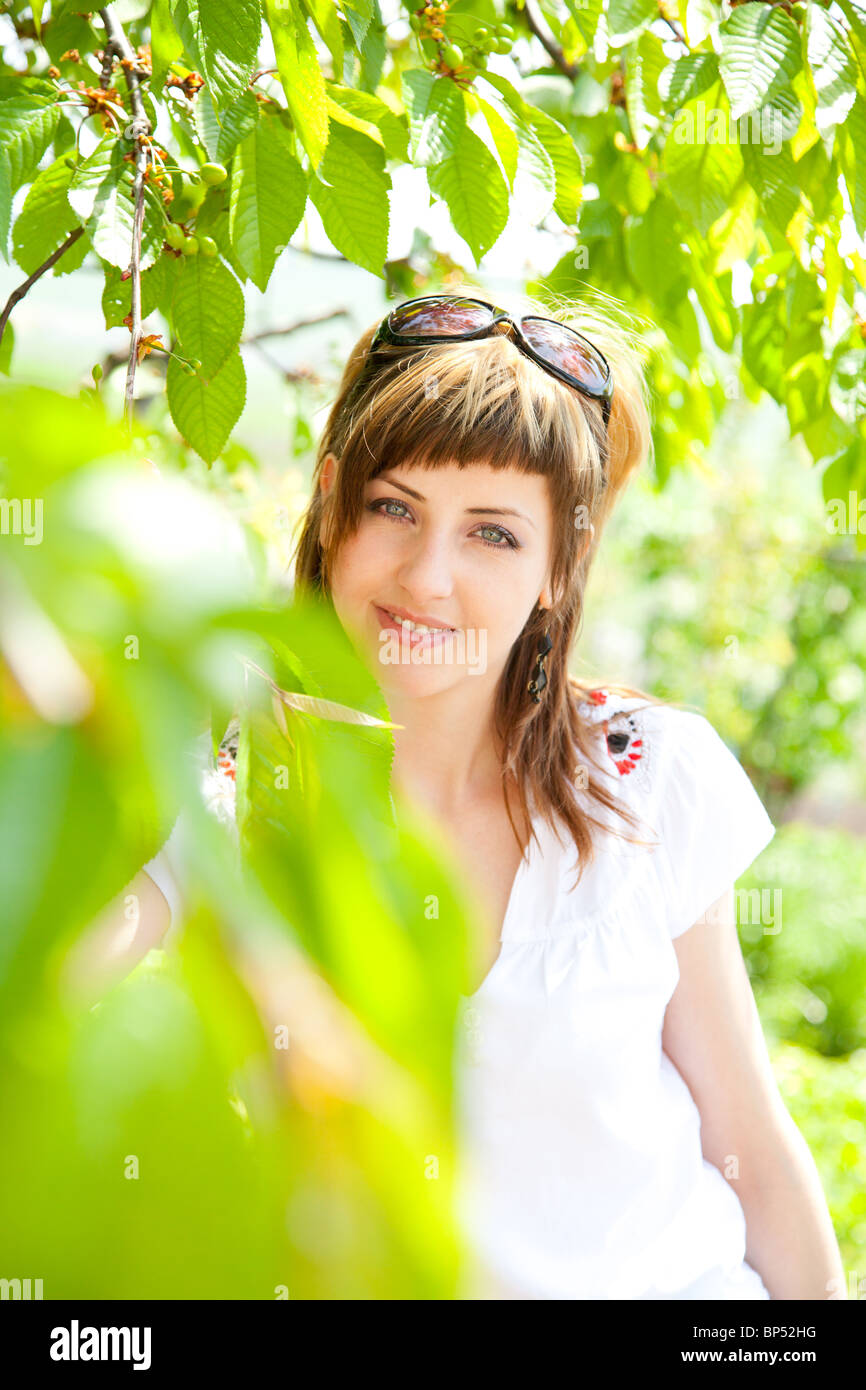 Young woman portrait sitting underneath a tree in spring Stock Photo ...