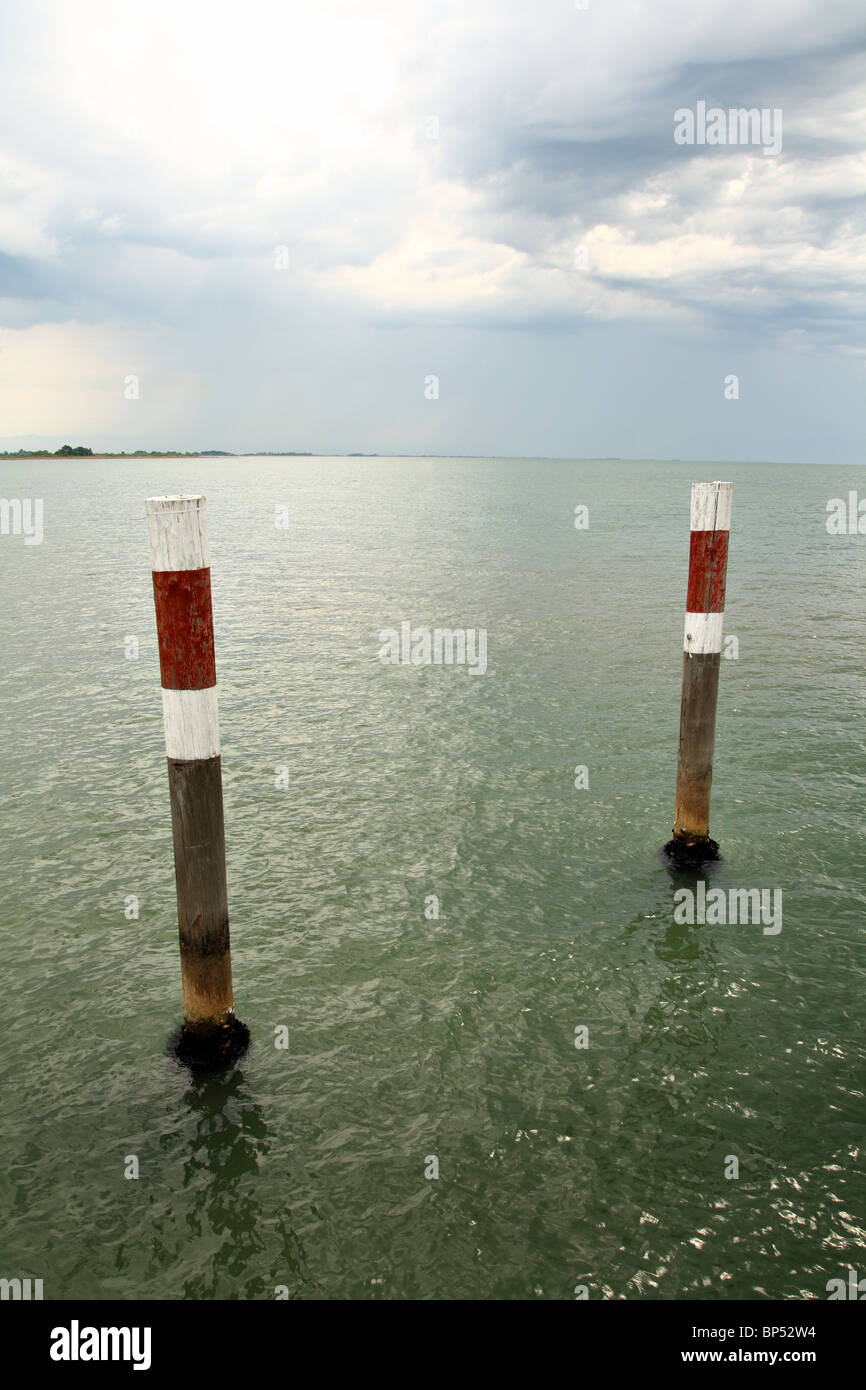 Two wooden signal columns in the middle of sea waters Stock Photo - Alamy