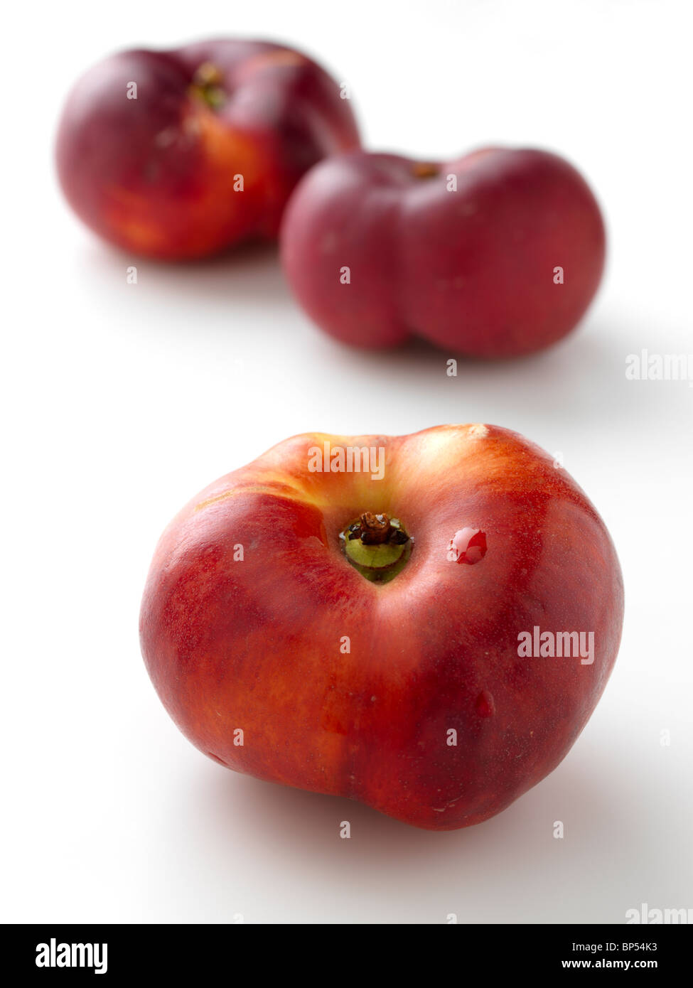 A pile of ripe peento nectarines on a white background Stock Photo - Alamy